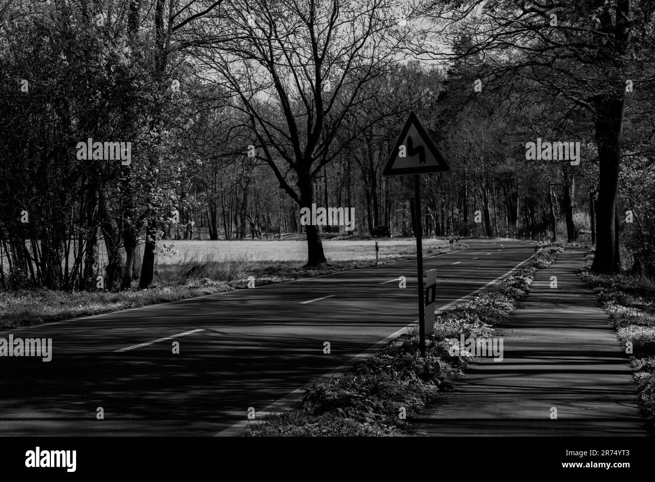 Country road in spring with traffic sign, Attention dangerous double ...
