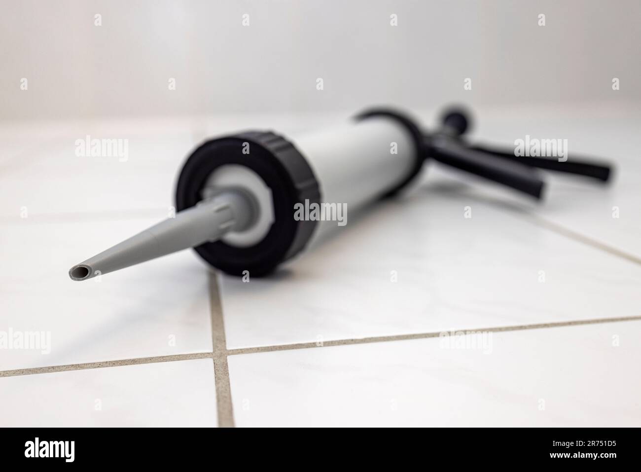 Cartridge press lies on floor tile, cartridge nozzle, blur Stock Photo ...