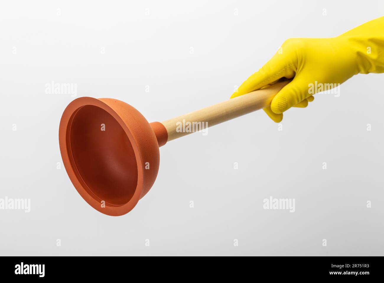 Hand holding plunger, protective glove yellow, white background Stock ...
