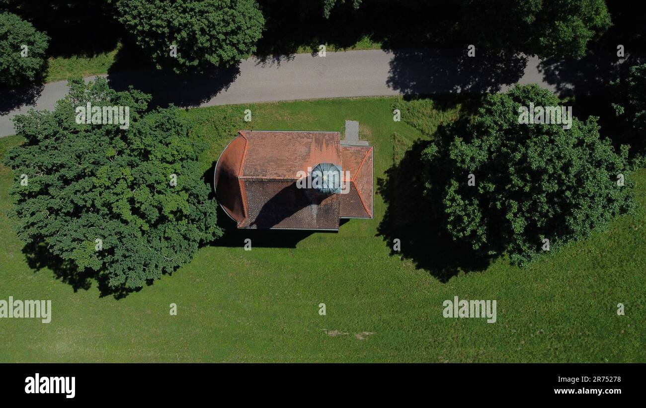 Aerial view of a rustic barn with a clock tower on top of its roof, set ...