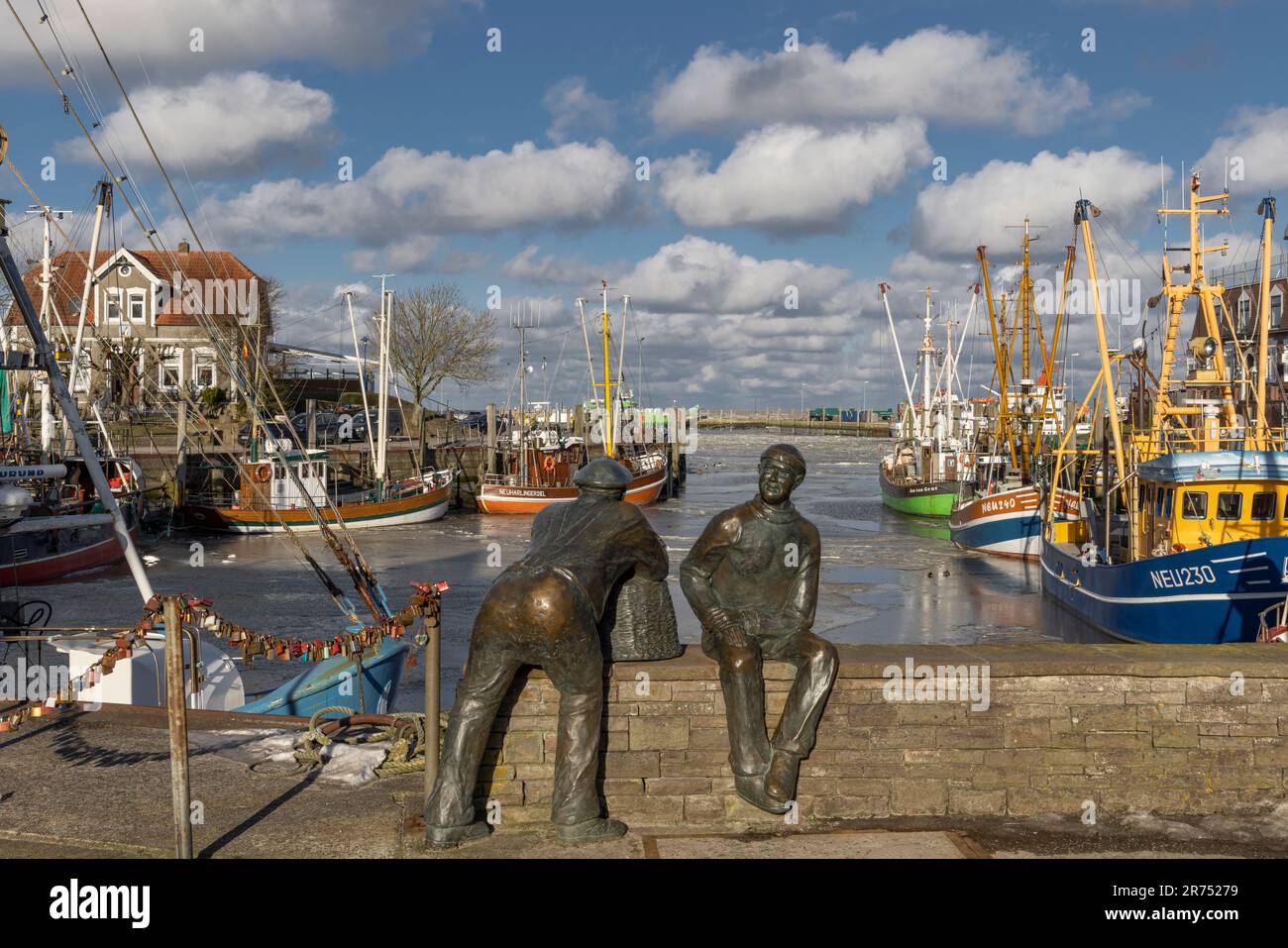 Winter atmosphere, icy harbor, fishing monument, old and young ...
