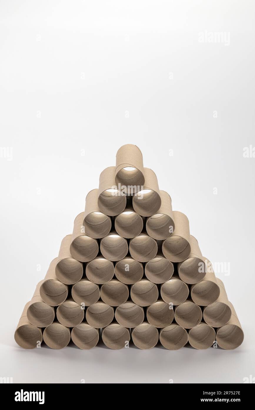 Many empty toilet paper rolls stacked as a pyramid, white background ...