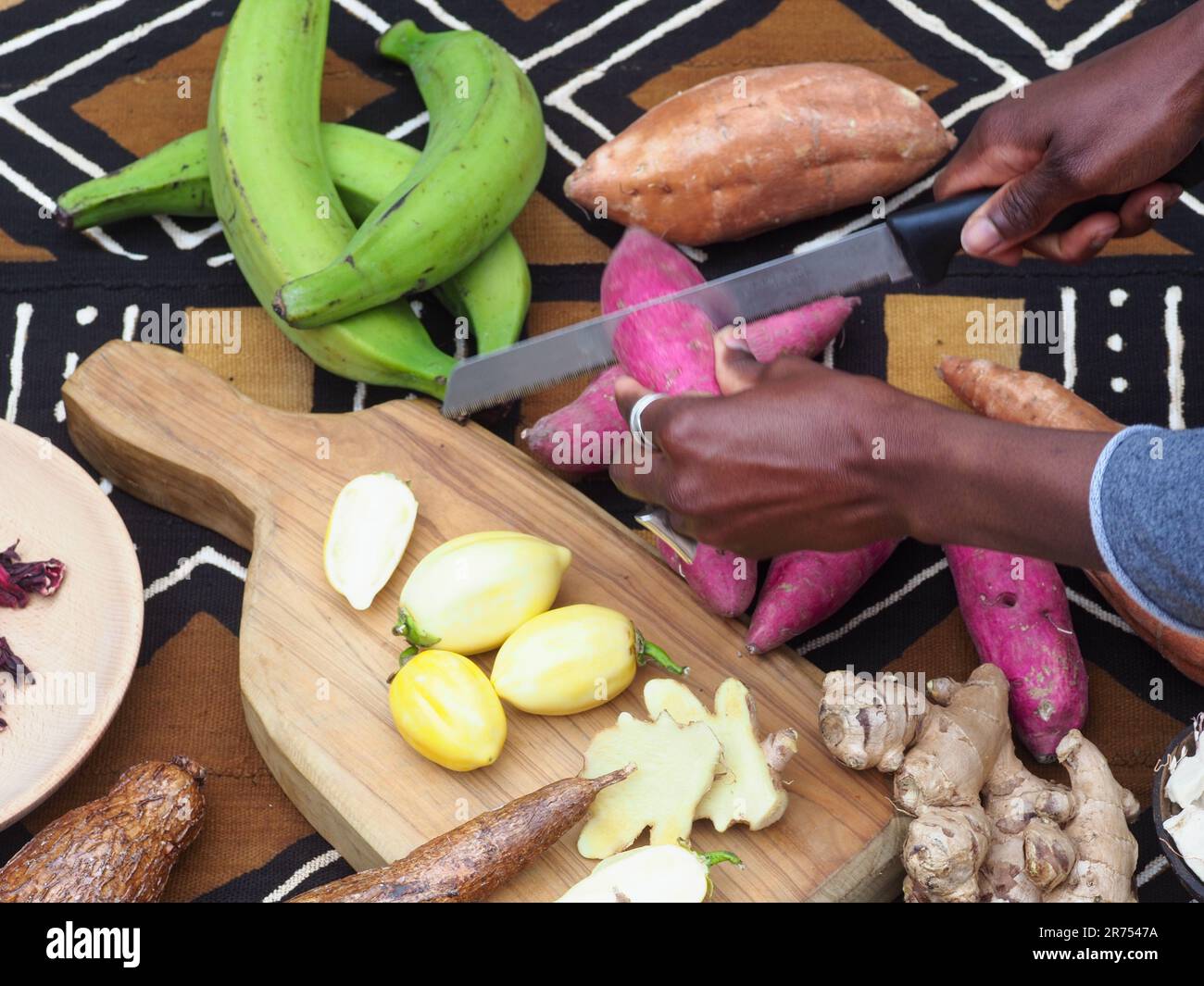 black woman cutting typical african veggies and fruits, overhead shot ...