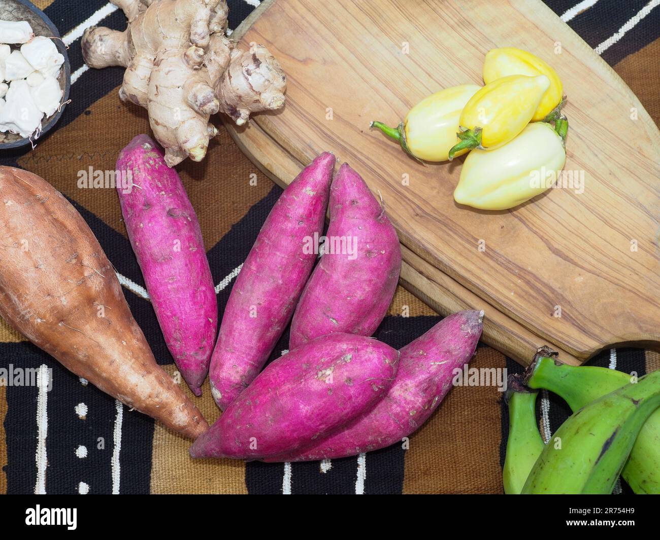 black woman holding African Red Sweet Potato, other local ingredients ...