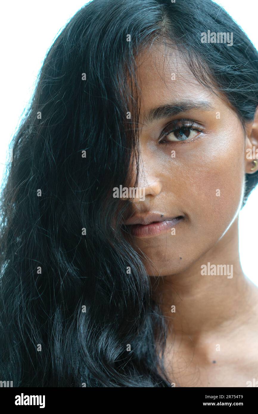 A portrait of a young woman with black hair covering half her face ...