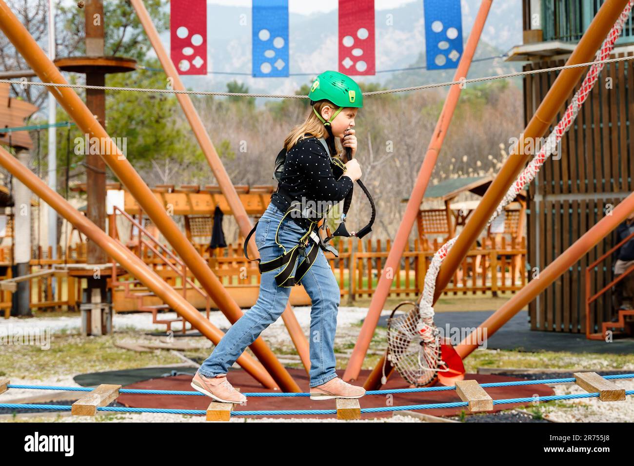 Teenage teen girl in climbing harness equipment, green sports safety ...