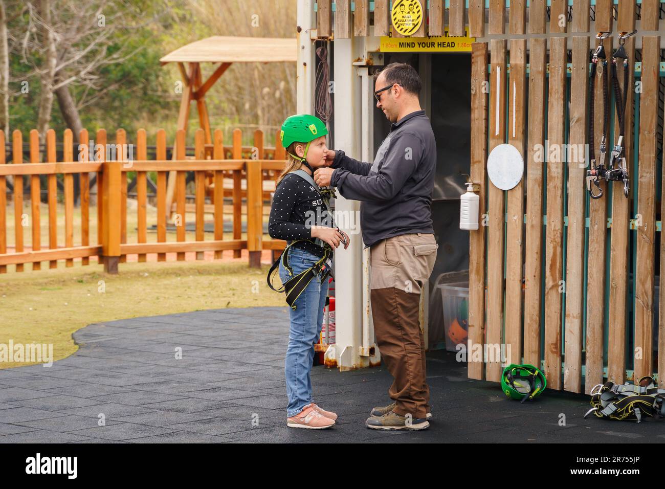 Teenage teen girl in climbing harness equipment, green sports safety ...
