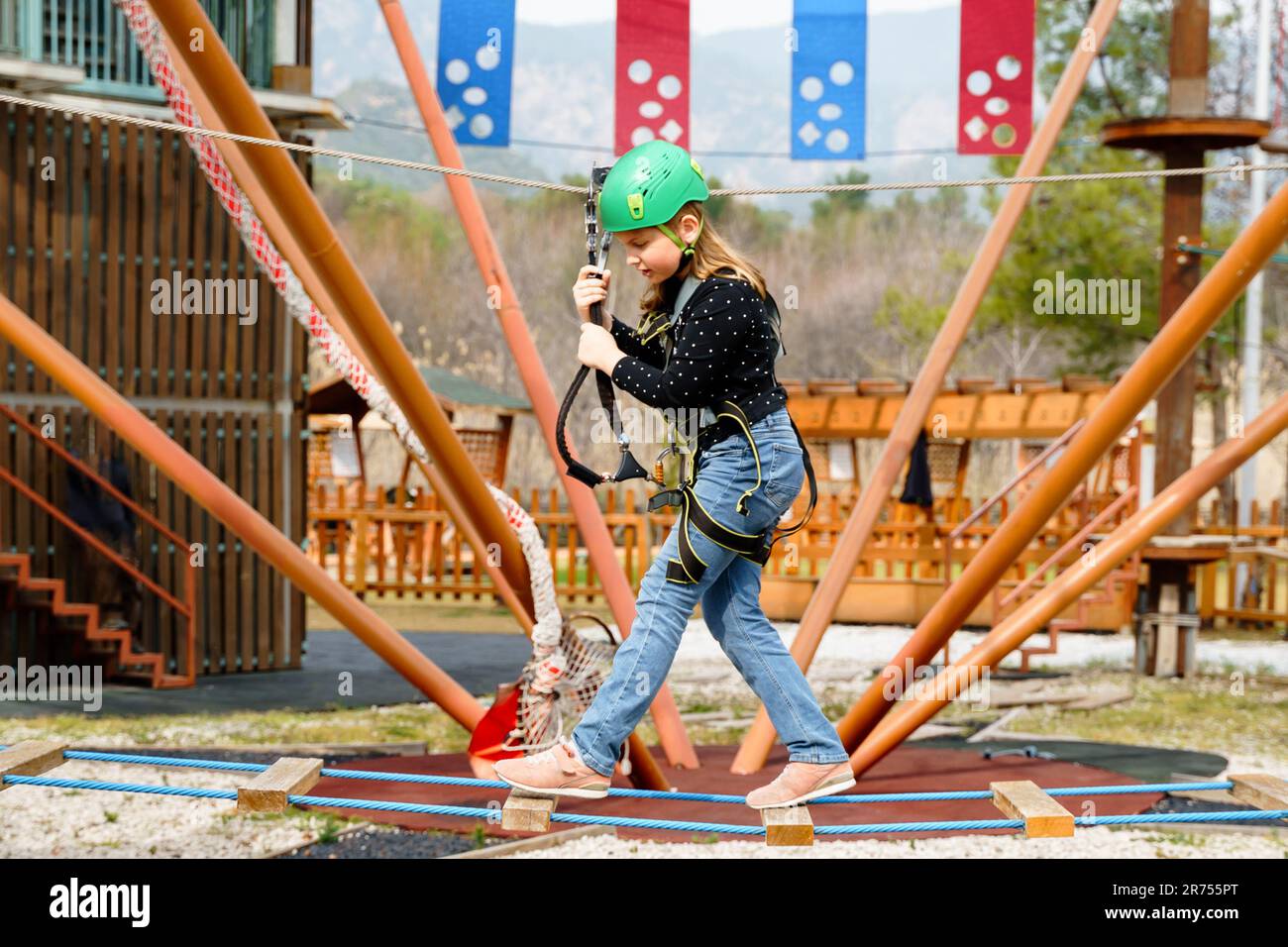 Teenage teen girl in climbing harness equipment, green sports safety ...