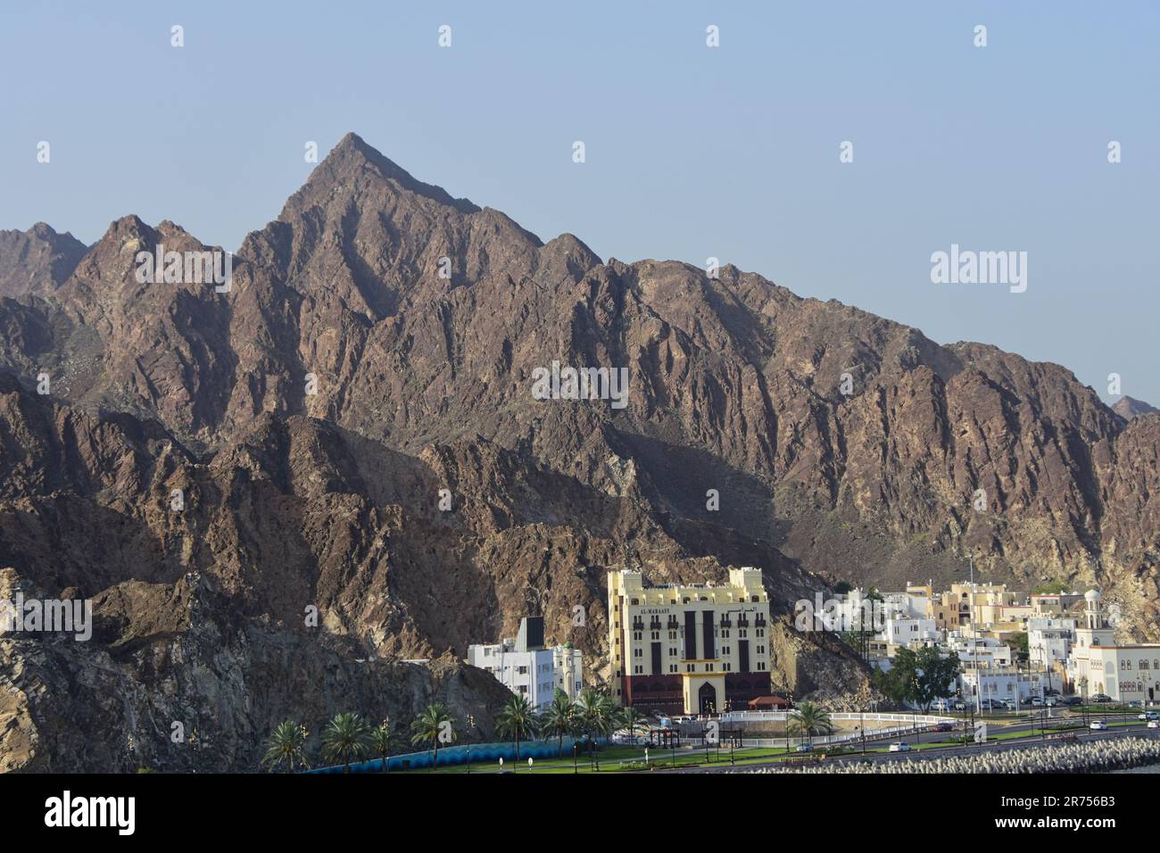 A scenic view of a cityscape with jagged mountains in the background in ...