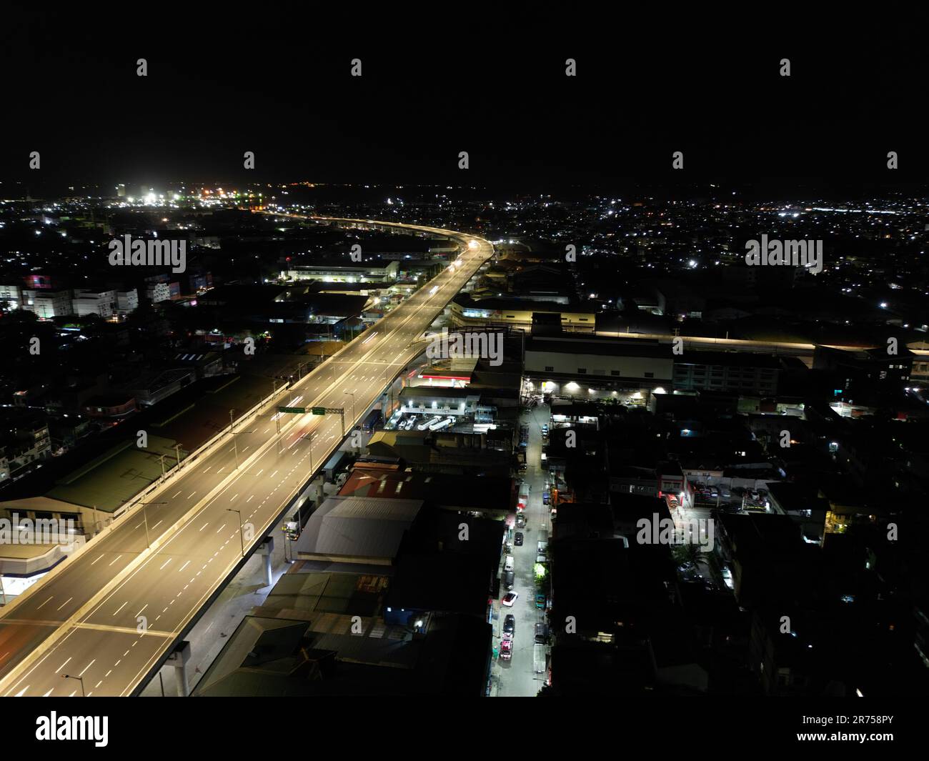 Night view of a long freeway lit up with cars driving in the vicinity ...