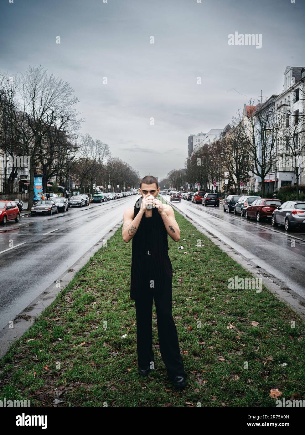 Man, black clothes, roadway, median, meadow, standing, rainy Stock ...
