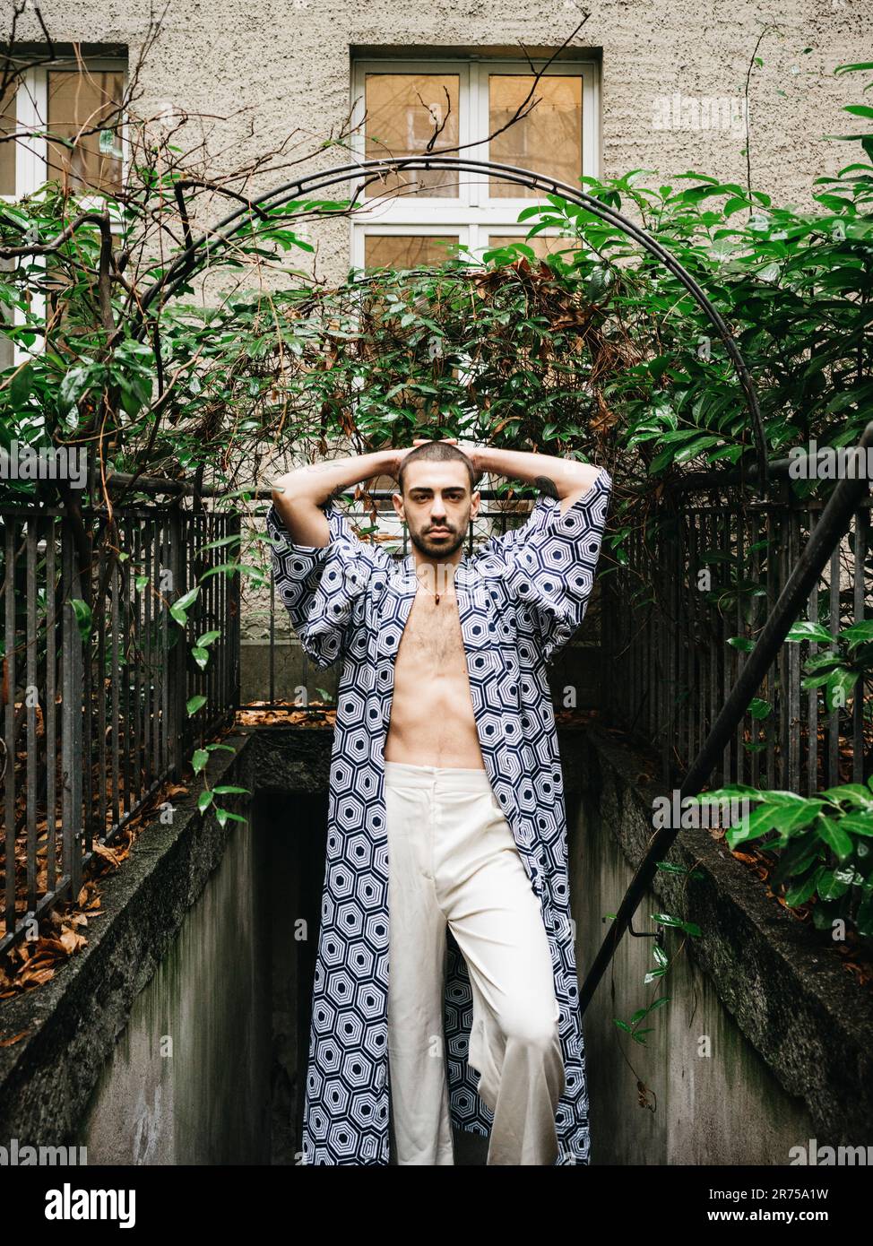 man, short hair, coat, basement stairs, standing, look camera, pose ...