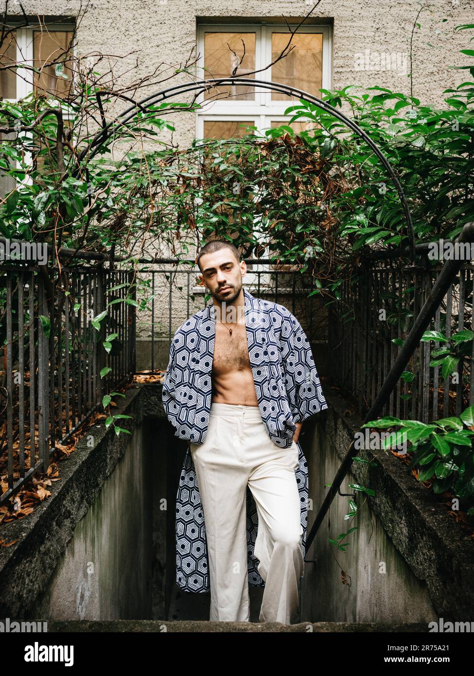 man, short hair, coat, basement stairs, standing, look camera, pose ...