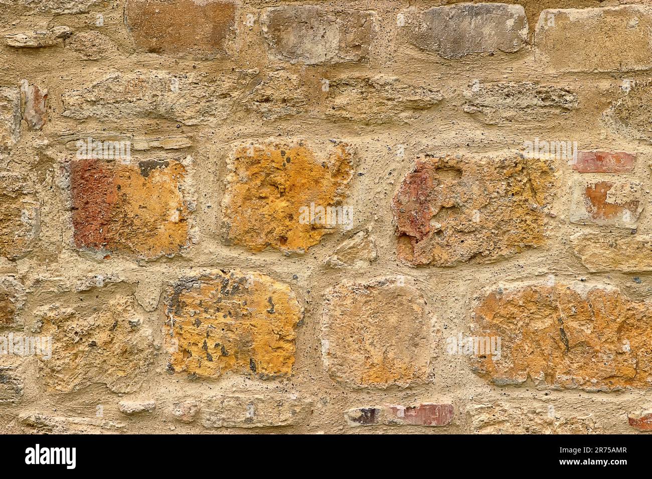 the stone wall is made of colored, large stones, tightly stacked on top ...