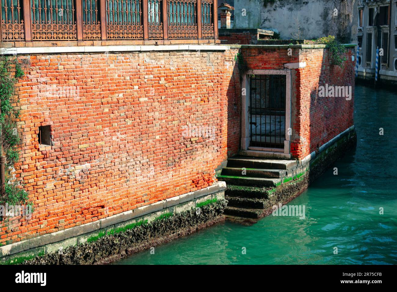 Water canal and brick wall in Venice . Stone stairs to water in Venezia ...