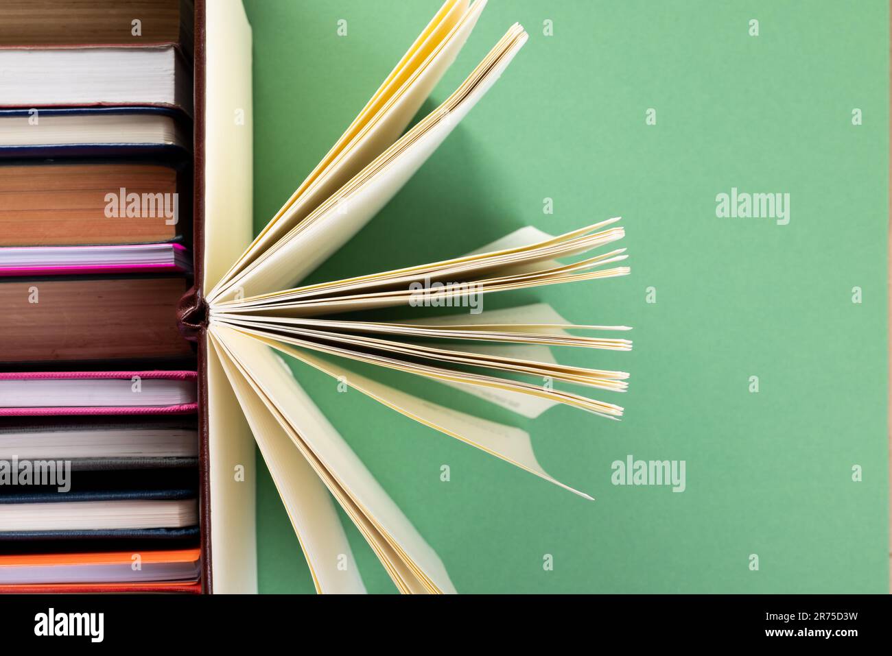 Books and notebooks in row with opened notebook on top and copy space ...