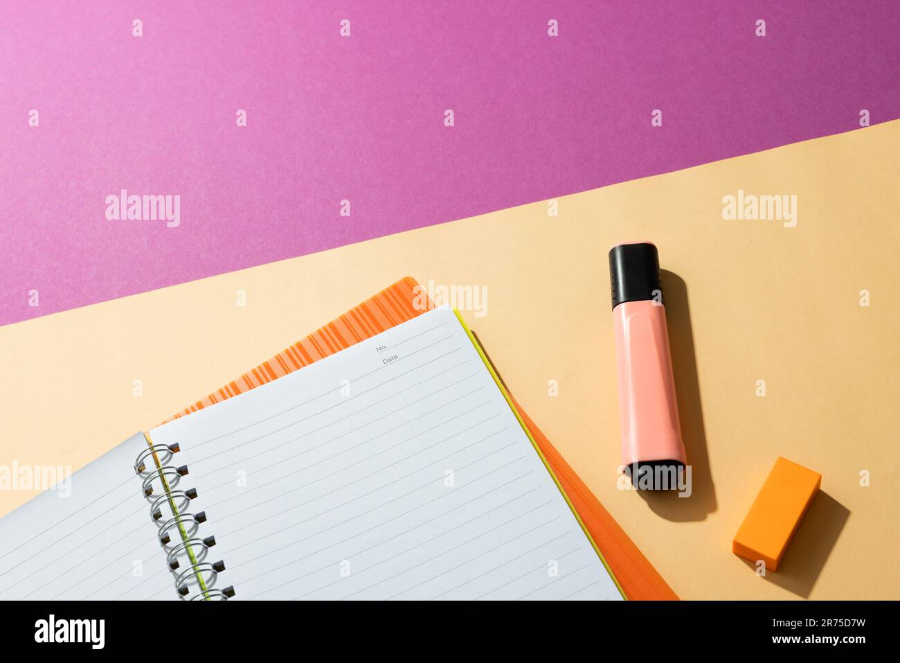 Flat lay of notebooks and highlighter with copy space on pink and ...