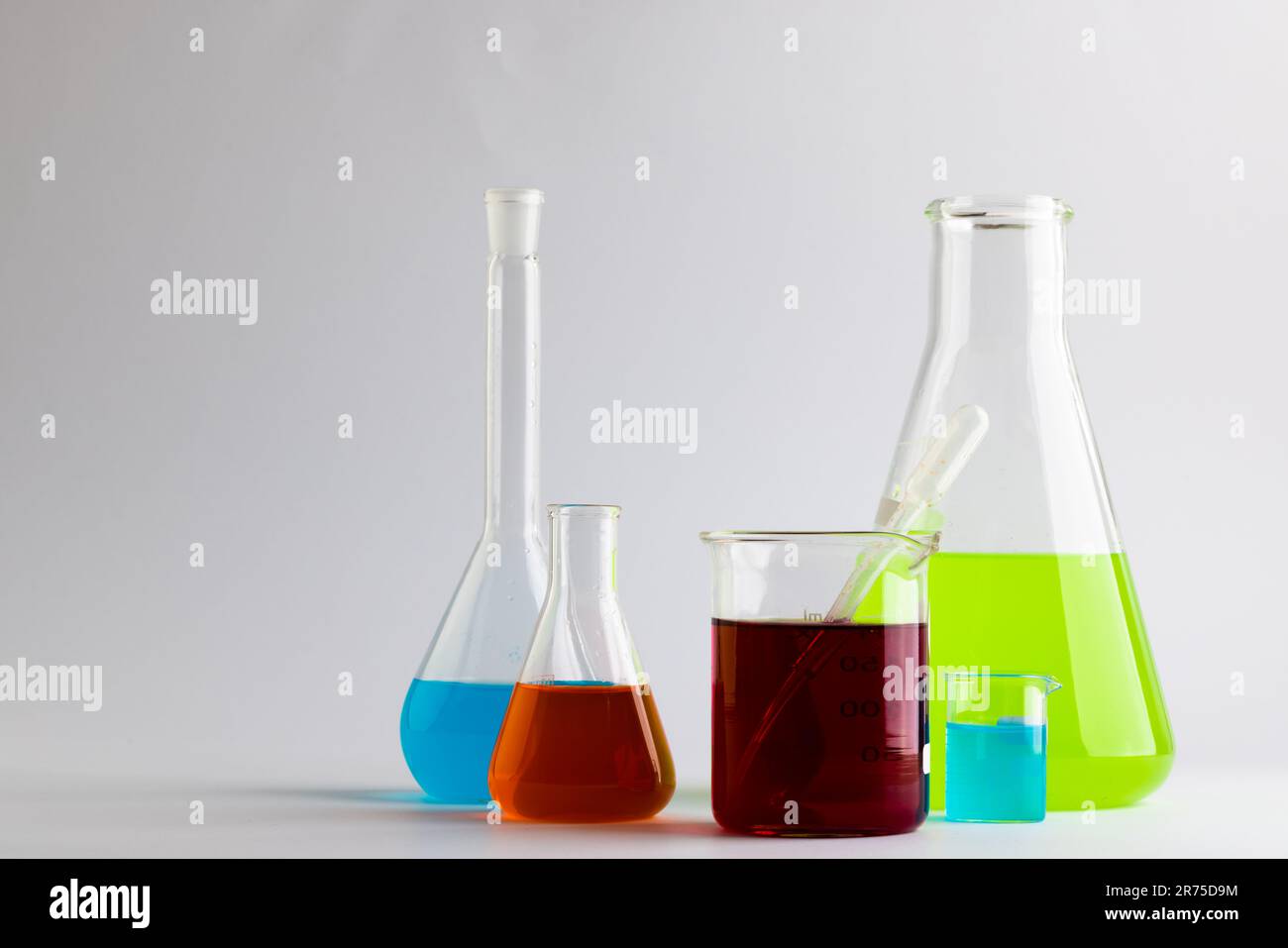 Close up of chemistry test tubes and dishes with copy space on white ...