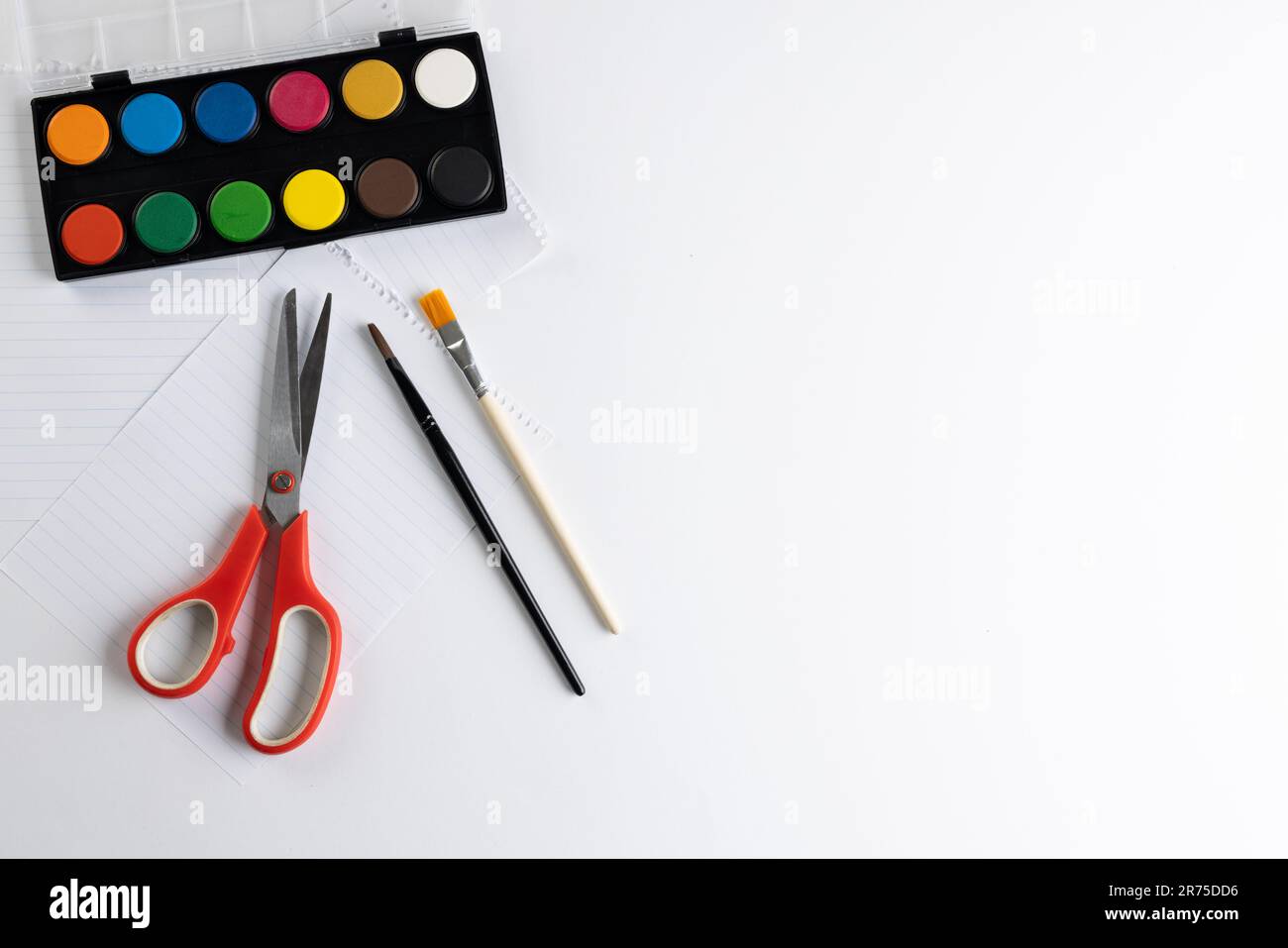 Close up of paints, paper, scissors and brushes with copy space on ...