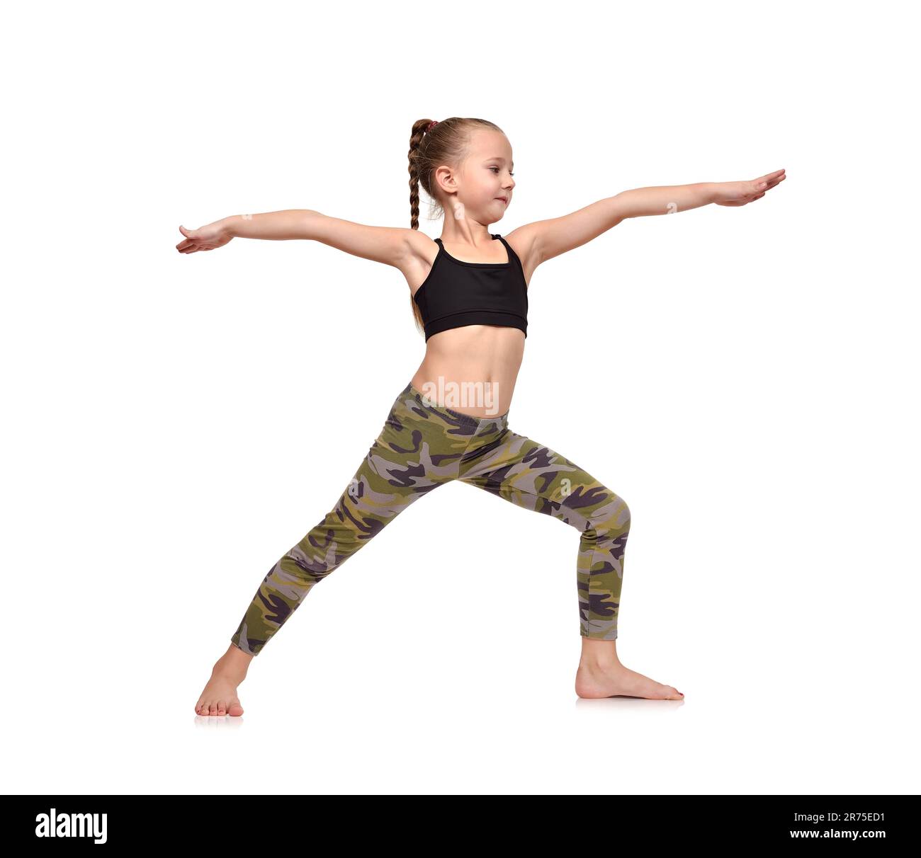 Active little girl doing yoga exercise Stock Photo - Alamy