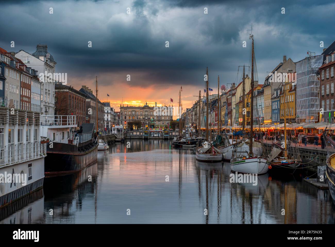 Sunset, rain clouds over Nyhavn with its colorful houses, is considered ...