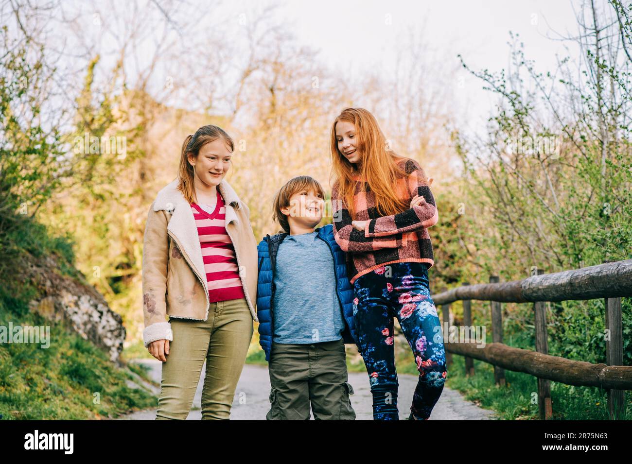 Group of 3 funny kids playing together in countryside, spring fashion ...