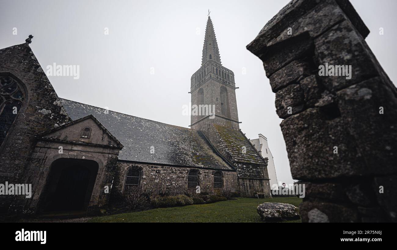 A beautiful church is seen, with its stone walls and luscious green ...