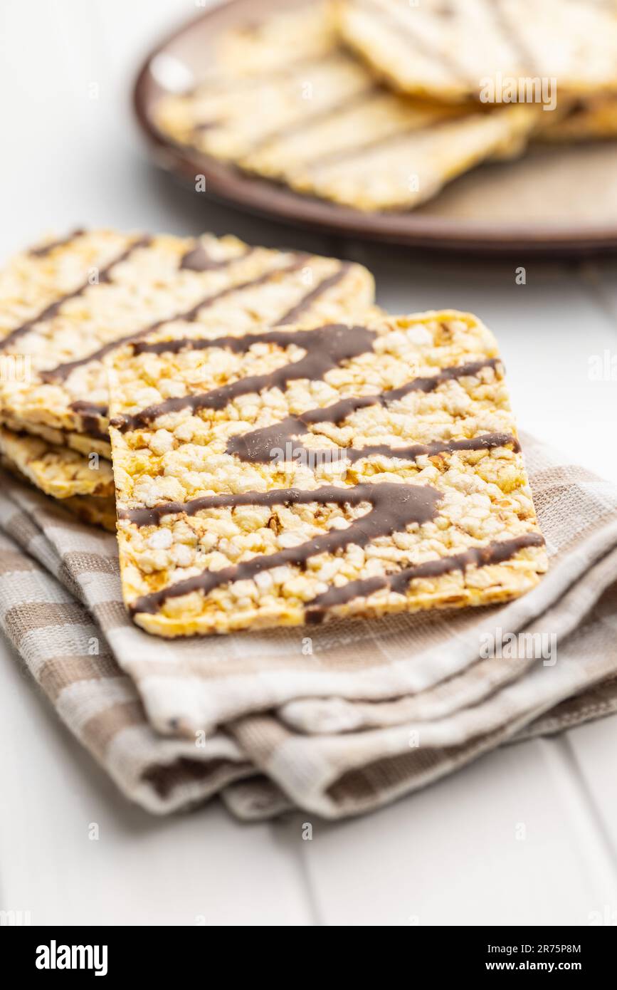 Puffed corn crackers chocolate covered on the white table Stock Photo ...
