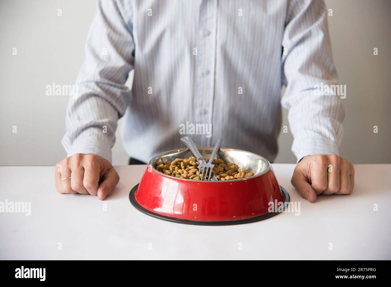Man eating dog food Stock Photo - Alamy