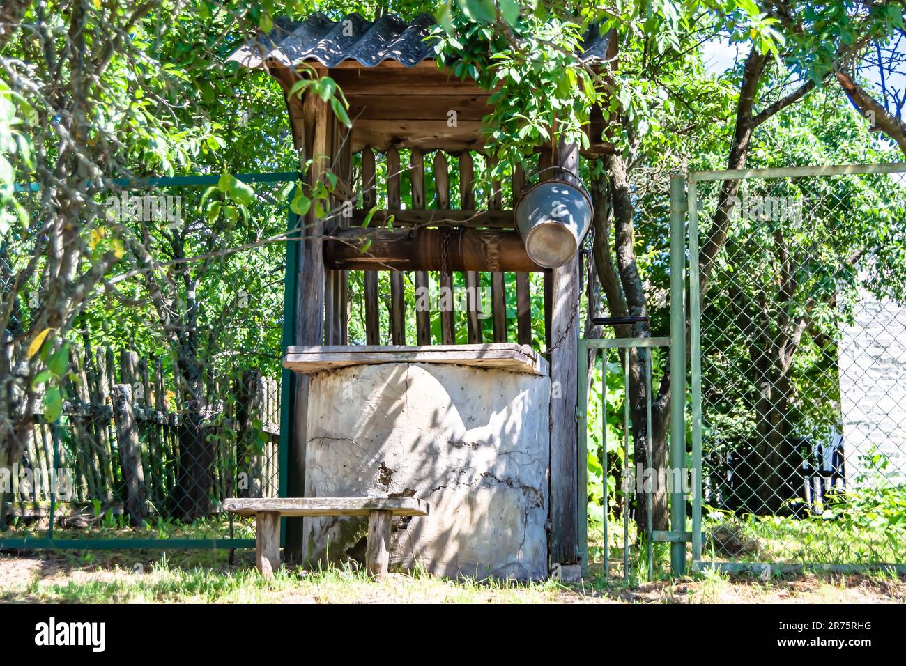 Old well with iron bucket on long forged chain for clean drinking water ...