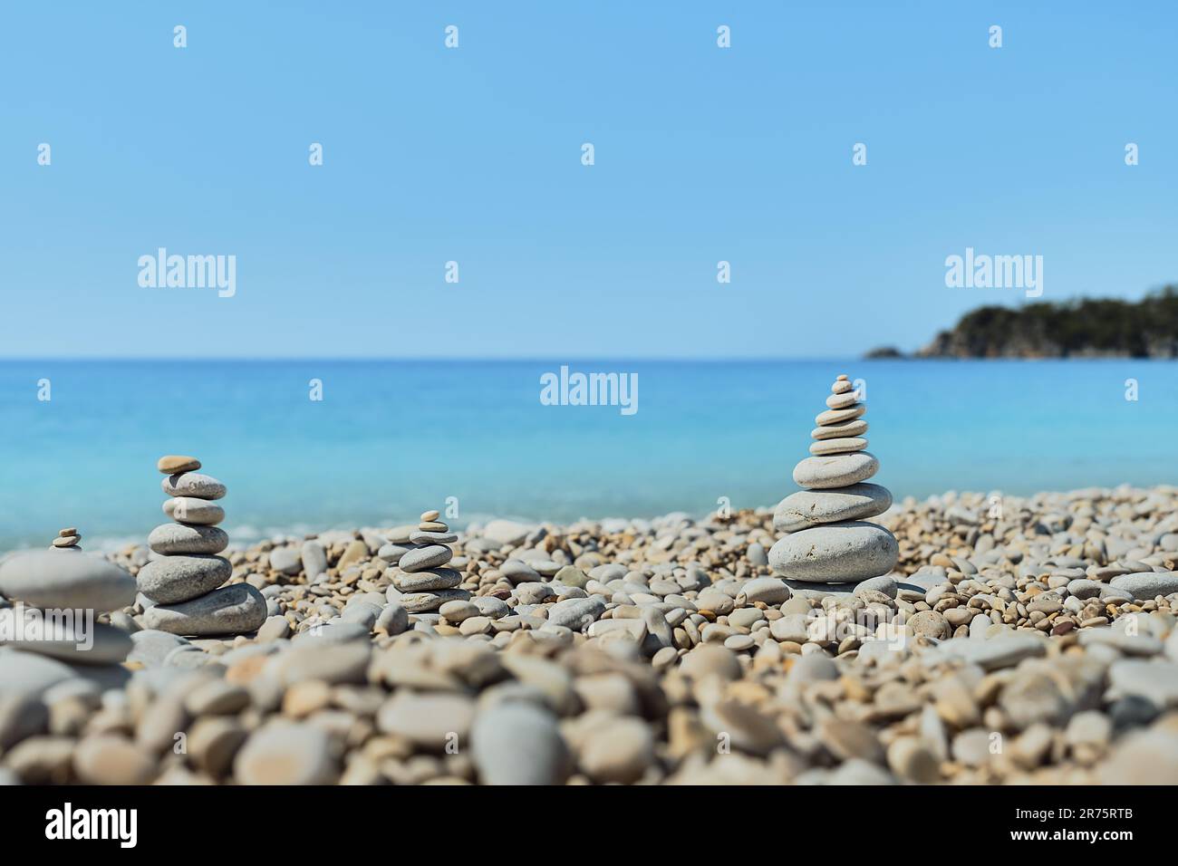 Pyramid stones balance on the beach against the background of the sea ...