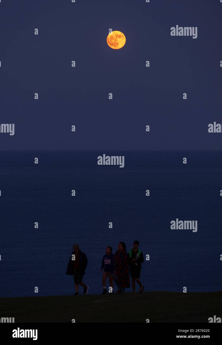 Full moon rising in a dark blue sky over the south coast of Cornwall ...