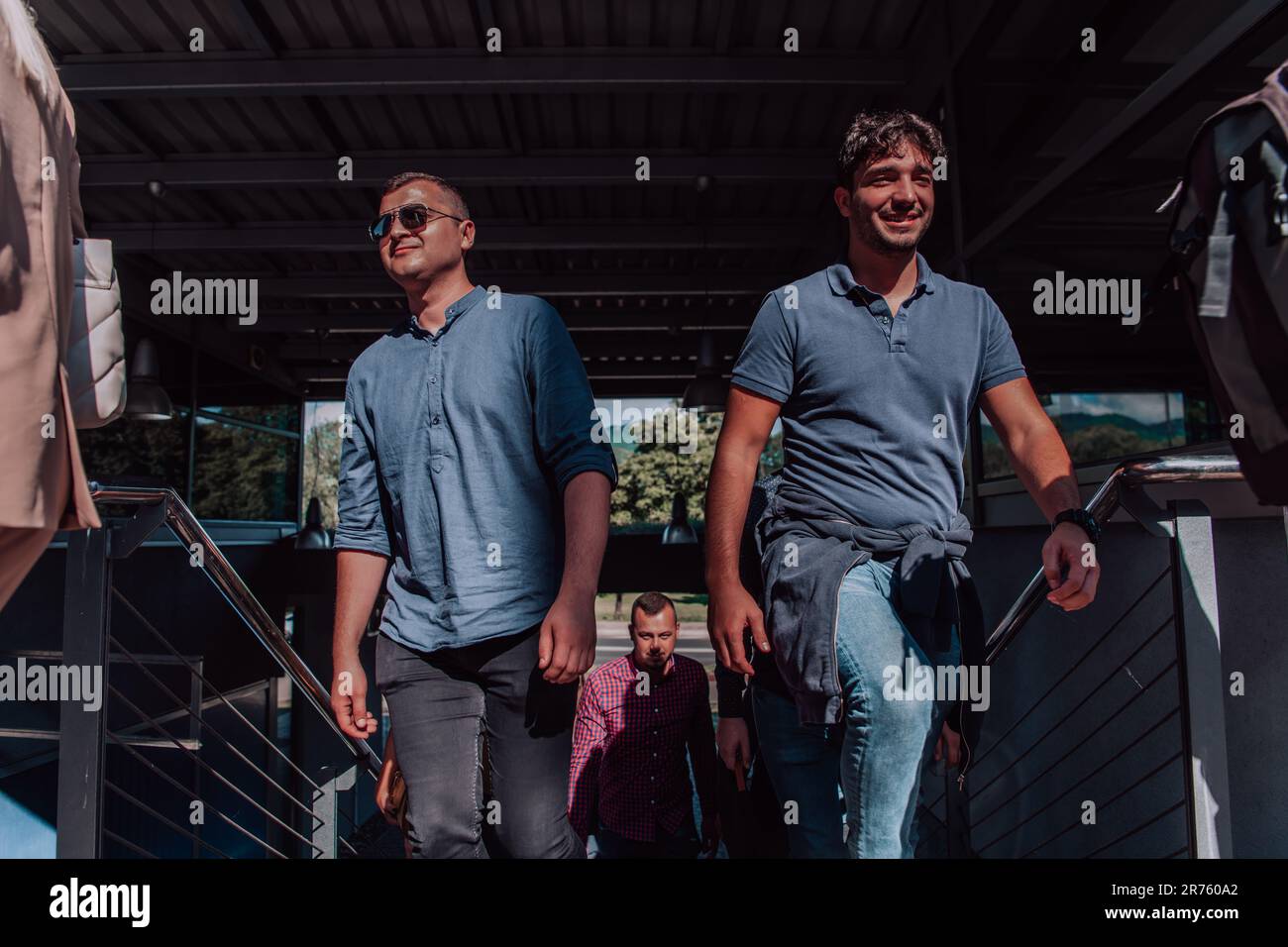 A diverse group of businessmen and colleagues walking together by their ...