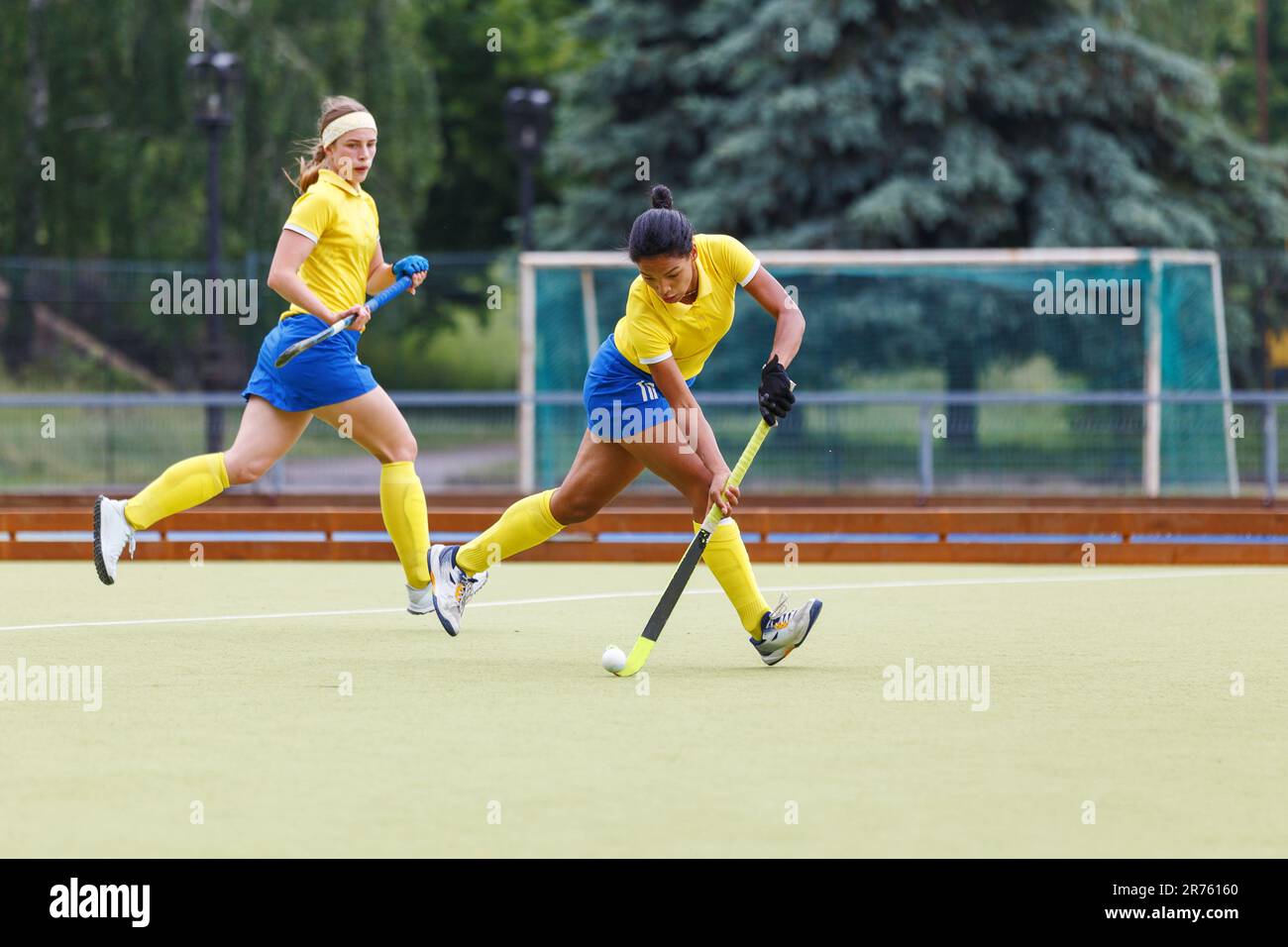Field hockey female player leading the ball in attack Stock Photo - Alamy