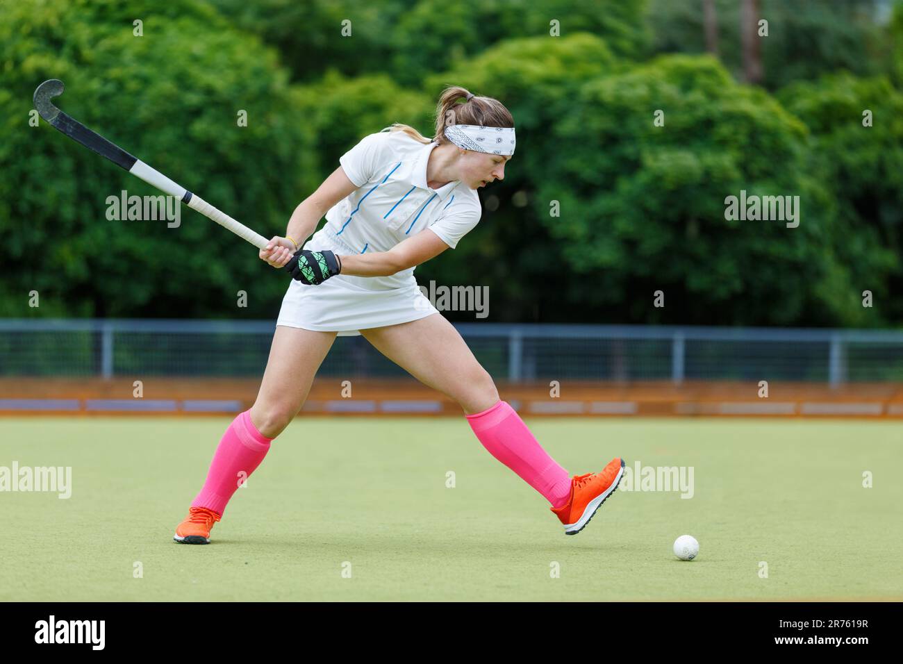 Field hockey female player hit the ball in the game Stock Photo - Alamy