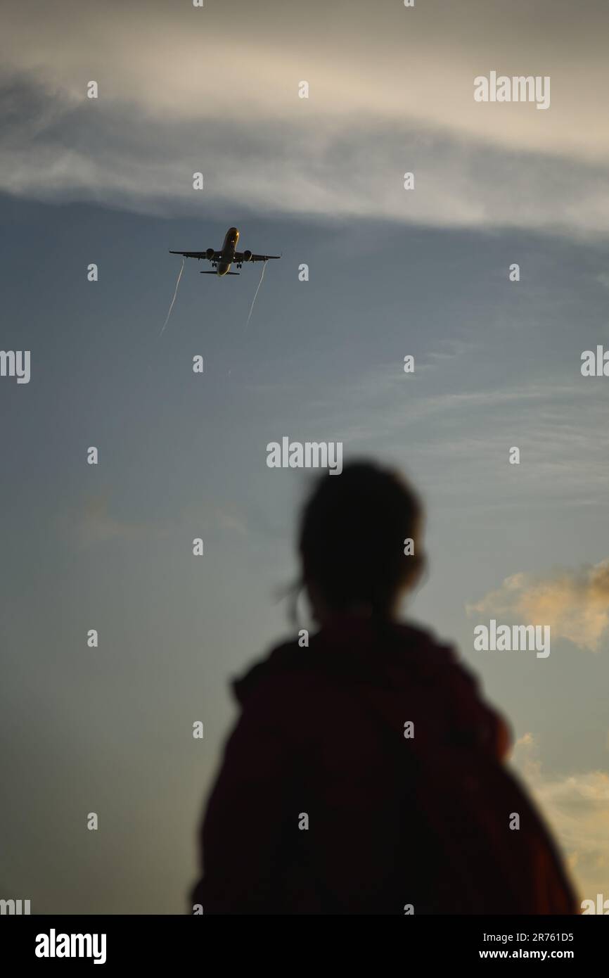 Aerial view of an airplane flying over an airport with people in the ...