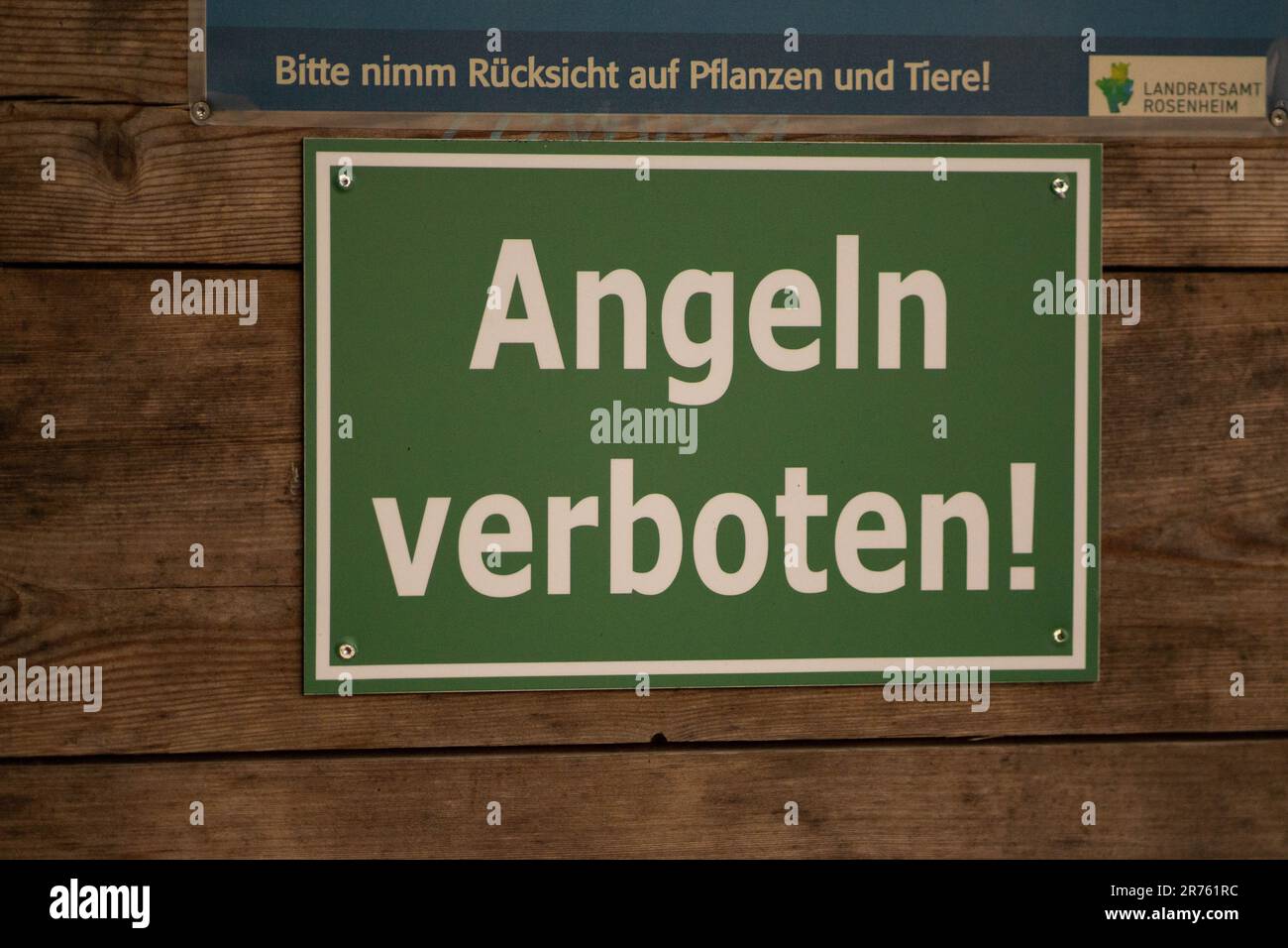 A vintage German sign displayed against a rustic wooden wall backdrop ...