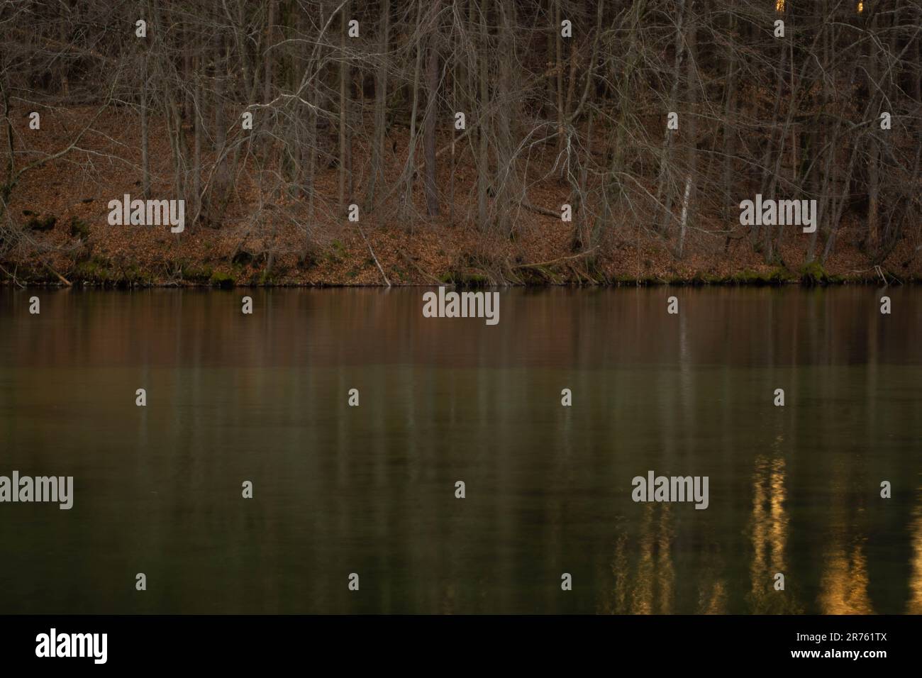 A tranquil lake, untouched and pristine, sits in the middle of an ...
