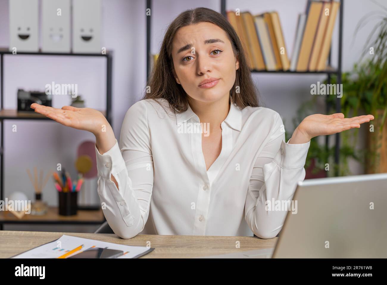 I dont know what to say. Confused business woman works on laptop at ...