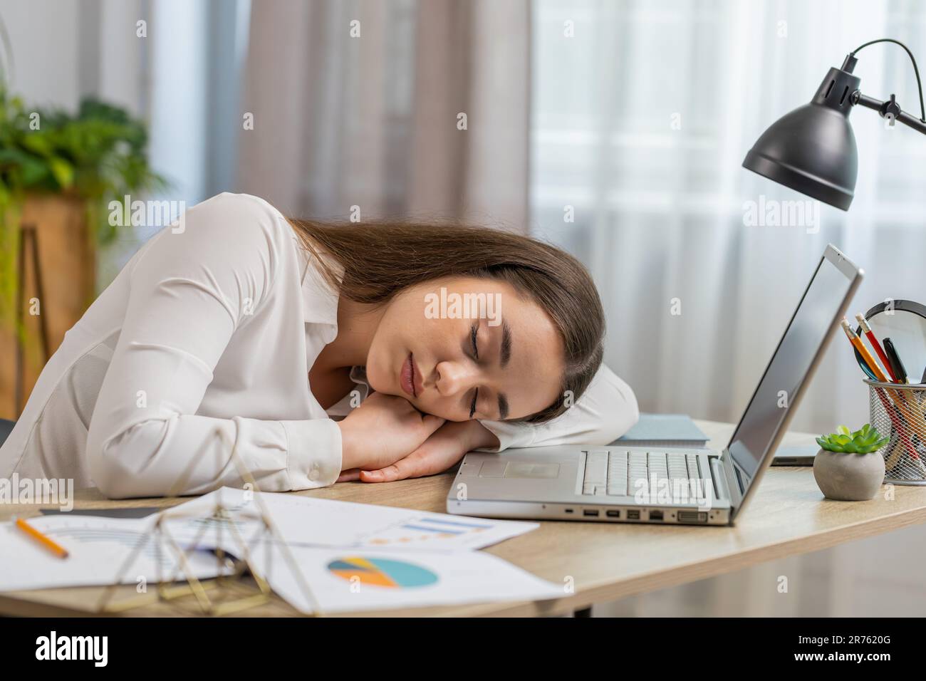 Bored sleepy Caucasian young business woman worker working on laptop ...