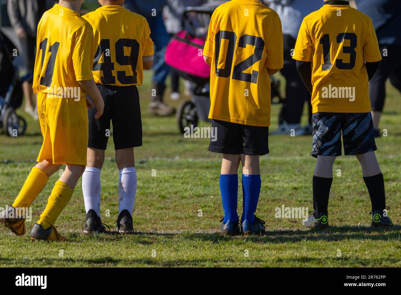 Two children wearing soccer uniforms stand in a field, ready to play ...