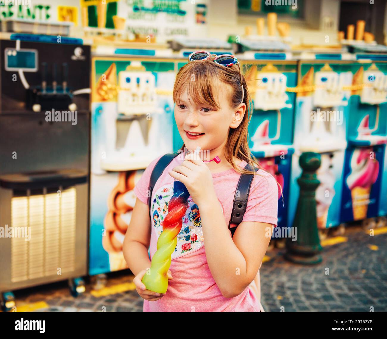 Cute little girl drinking colorful frozen slushie drink on hot summer ...
