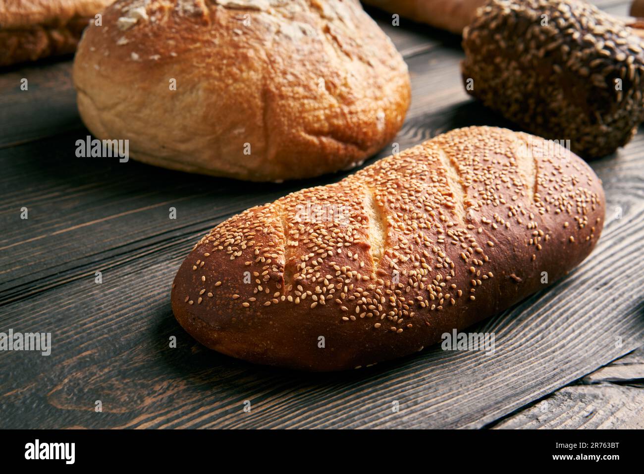 Different types of bread loaves on dark wooden background. Bakery ...