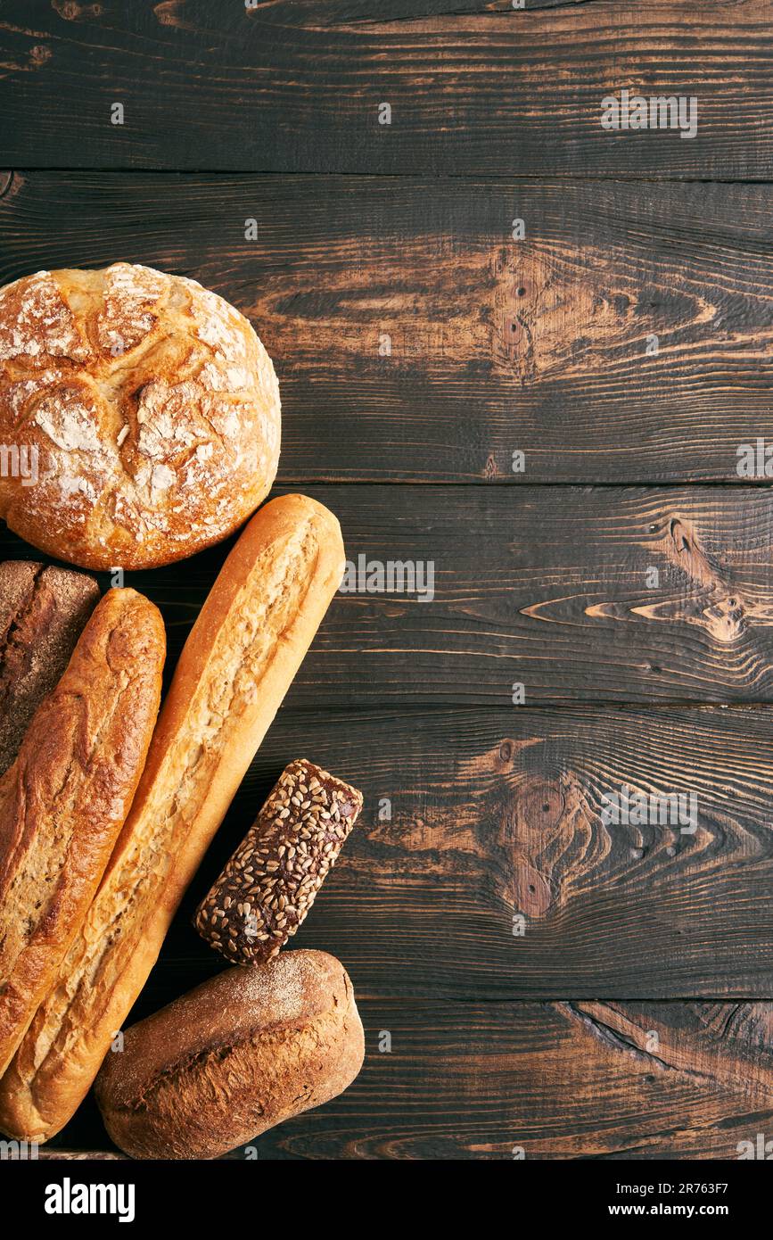 Different types of bread loaves on wooden background with copy space ...