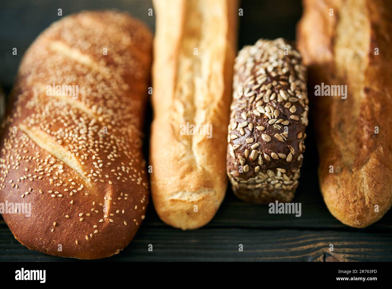 Different types of bread loaves on dark wooden background. Bakery ...
