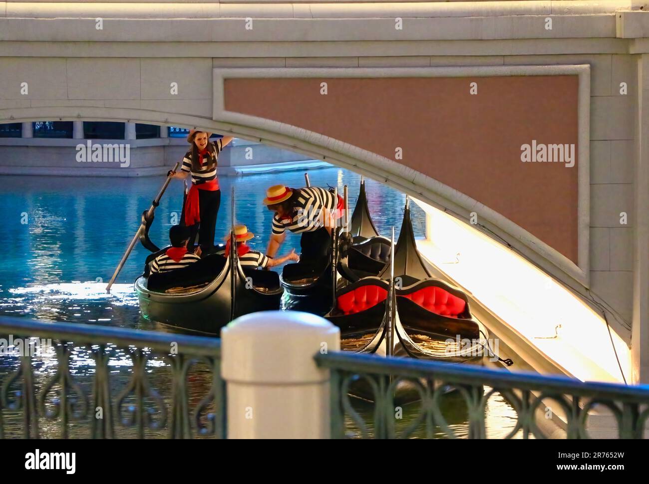 Gondolier workers at the end of the day under a bridge moving between ...