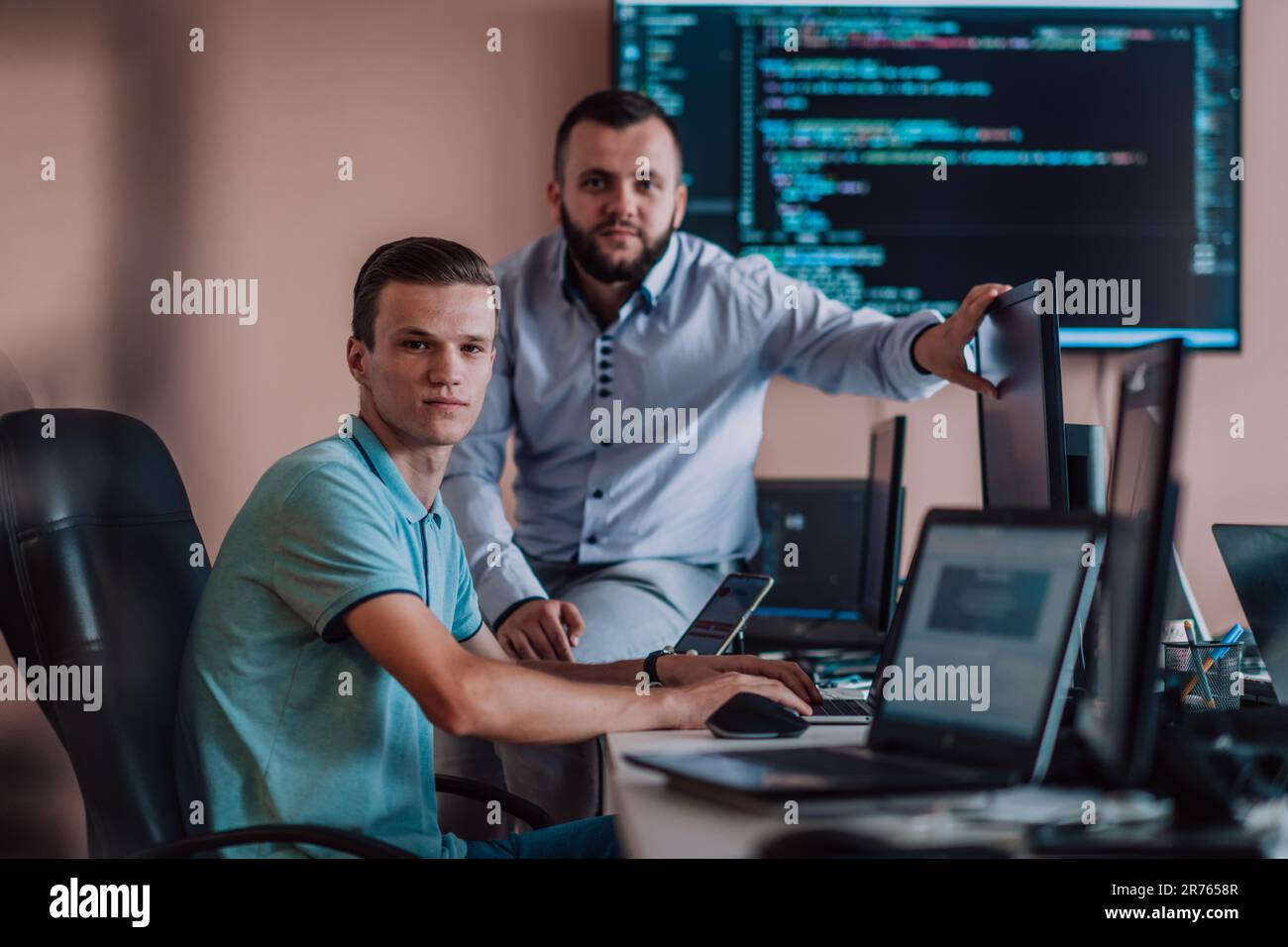 Programmers engrossed in deep collaboration, diligently working together to solve complex ...