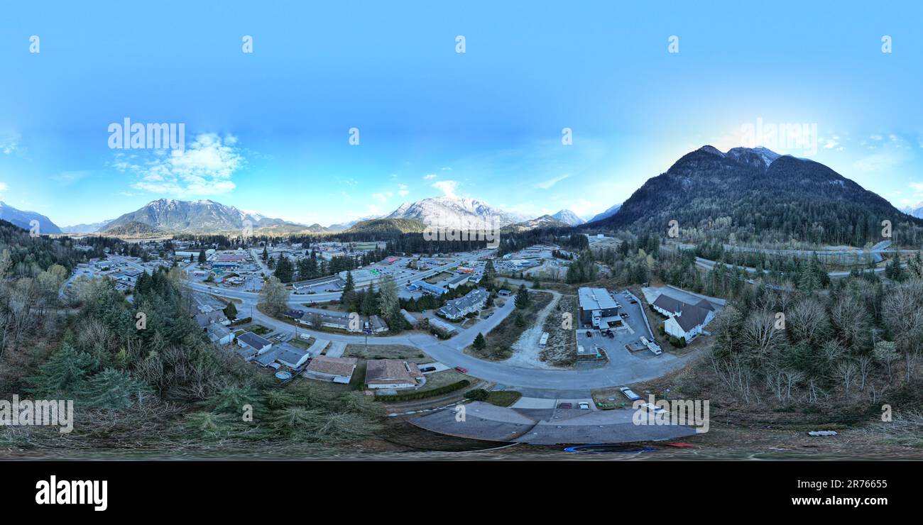 An aerial view of a rural village between the mountain range and trees ...