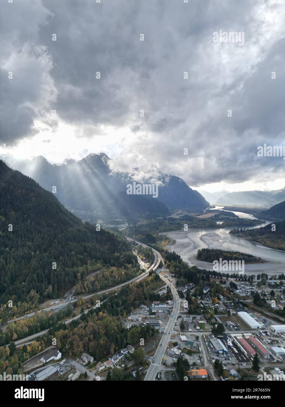 An aerial view of a rural village between the mountain range and trees ...