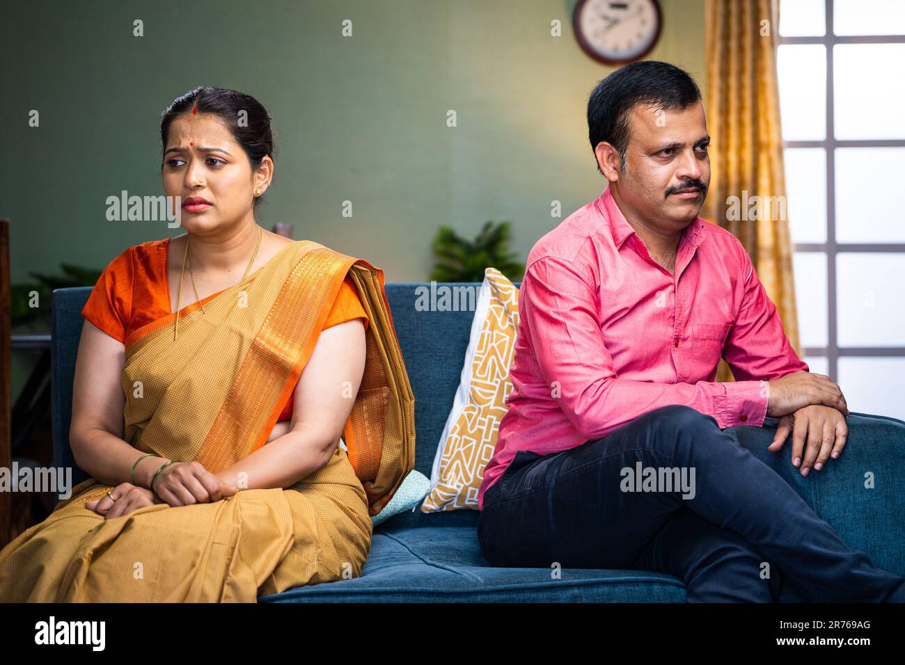 Indian angry middle aged couple sitting on sofa in opposite direction ...